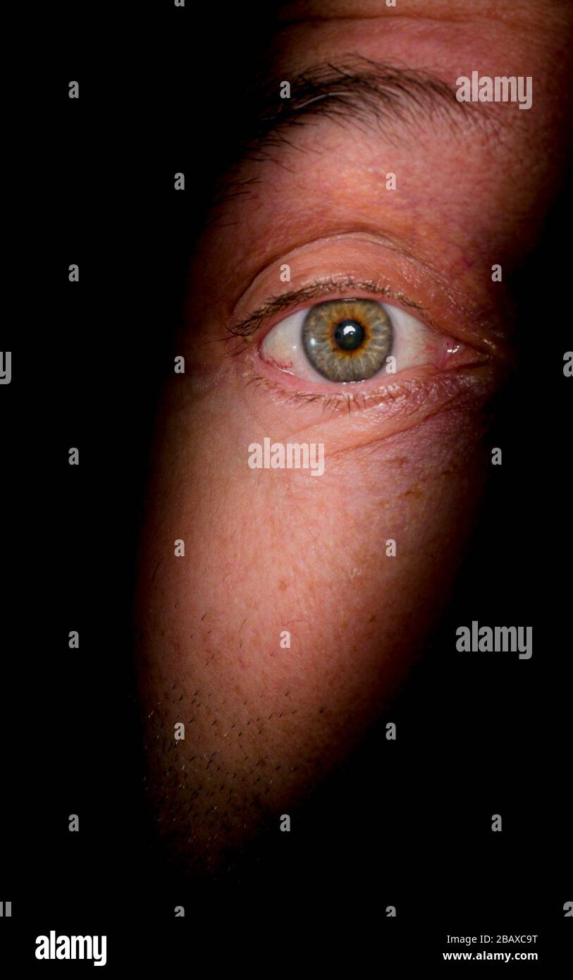 eyes spying concept through hole against dark background Stock Photo ...