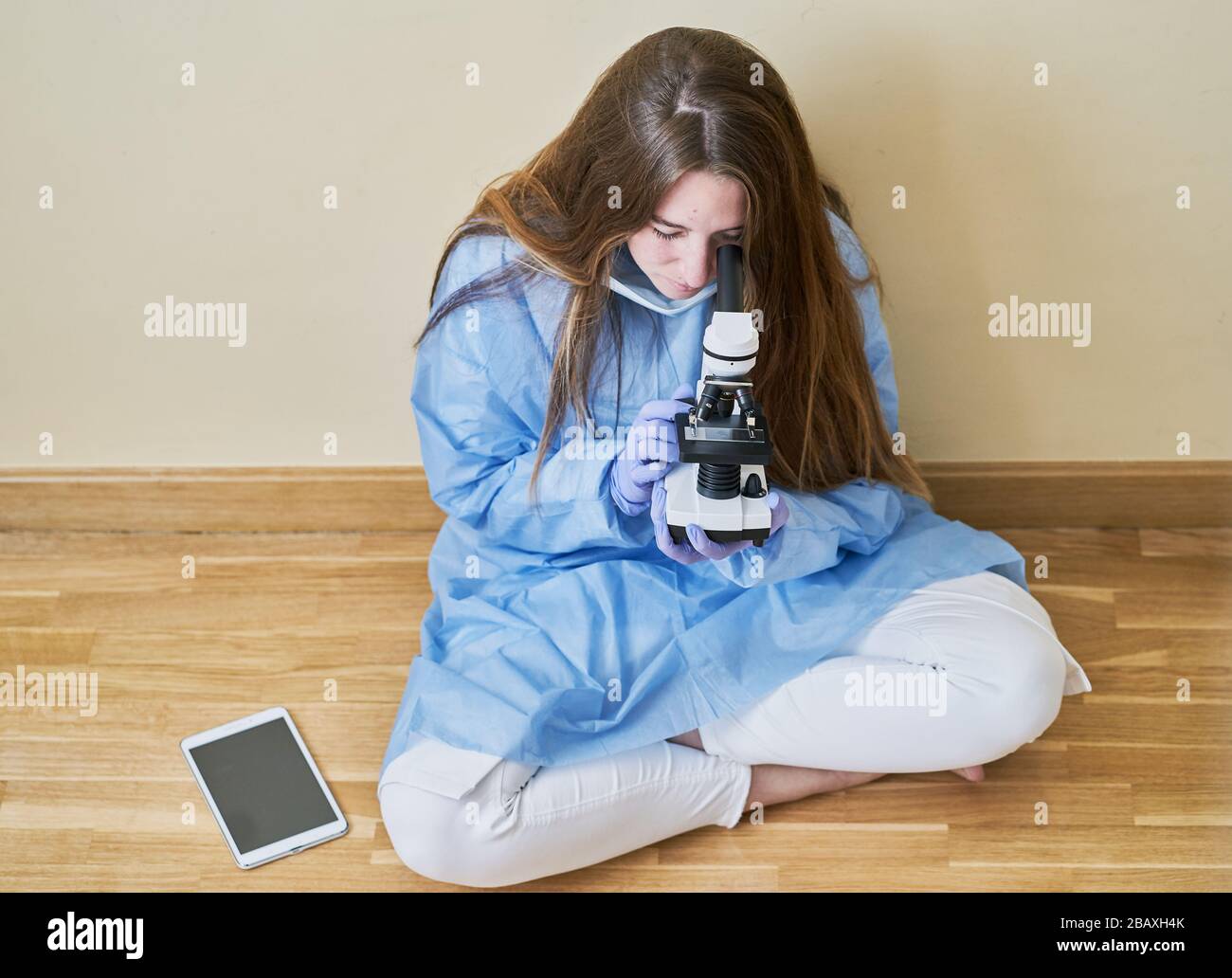 young medical researcher sitting on the floor of a classroom with a ...