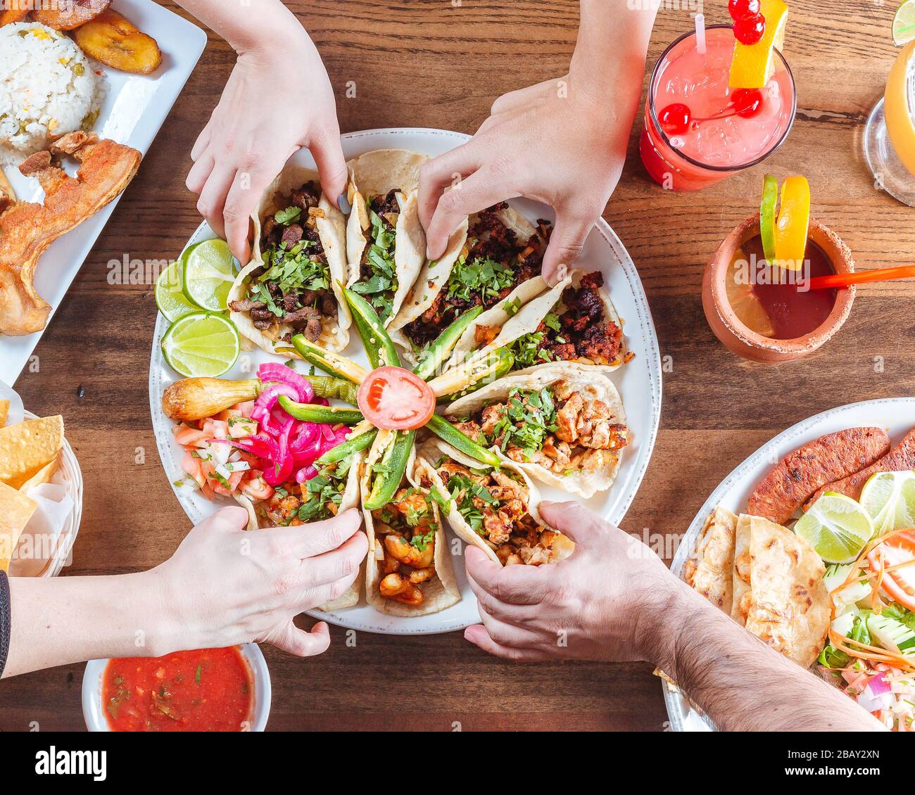 Mexican family taco plater on dark wood suraface with four people ...
