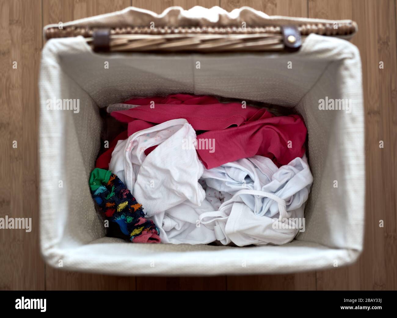 detail of the interior of an open laundry basket with different clothes ...