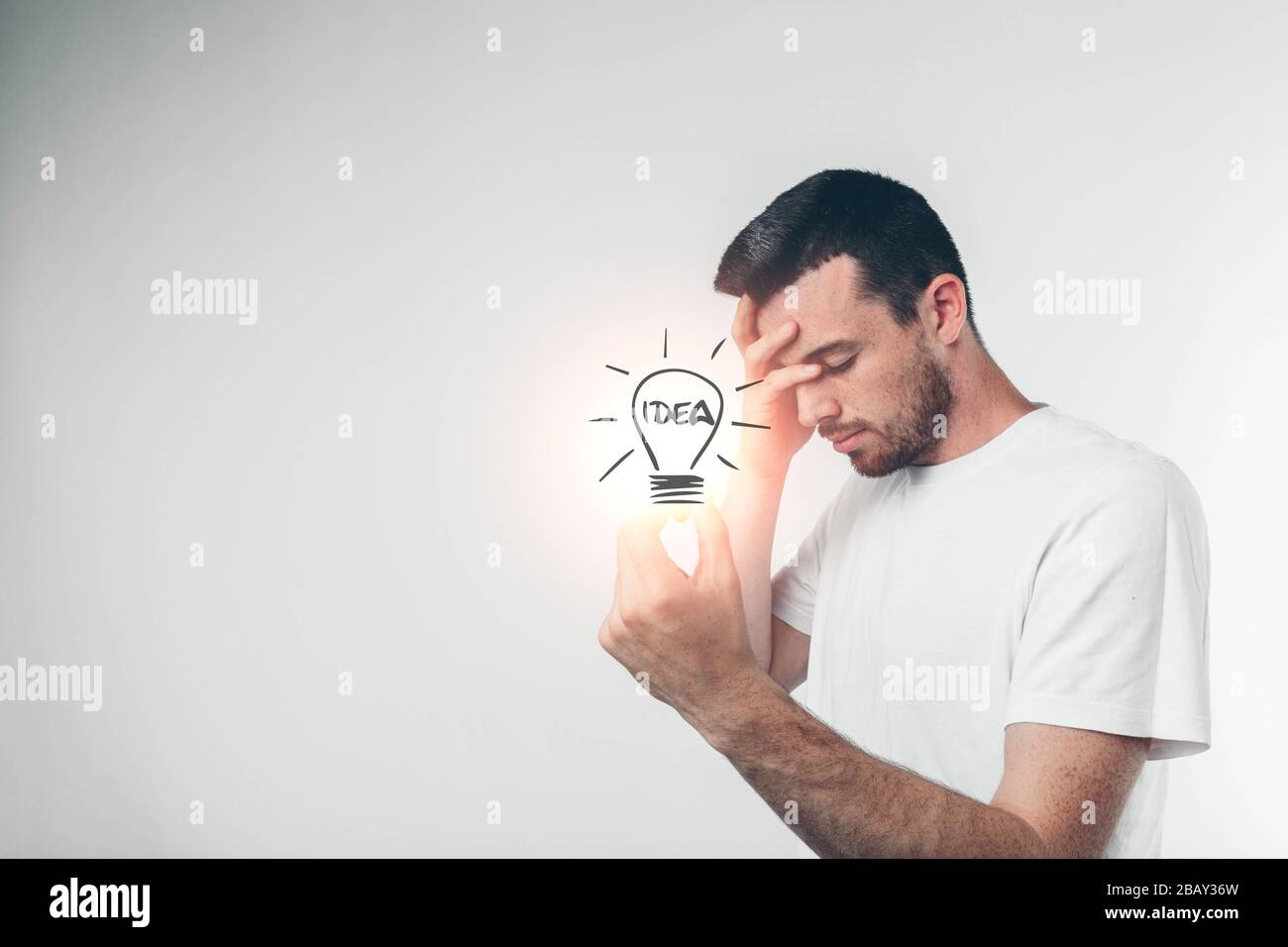 Portrait of young genious man holding lamp. Guy with an idea - isolated ...