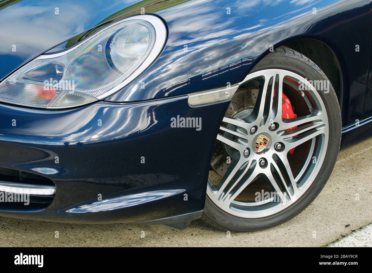 Silver five-spoke alloy wheel on front of dark blue Porsche Boxster ...