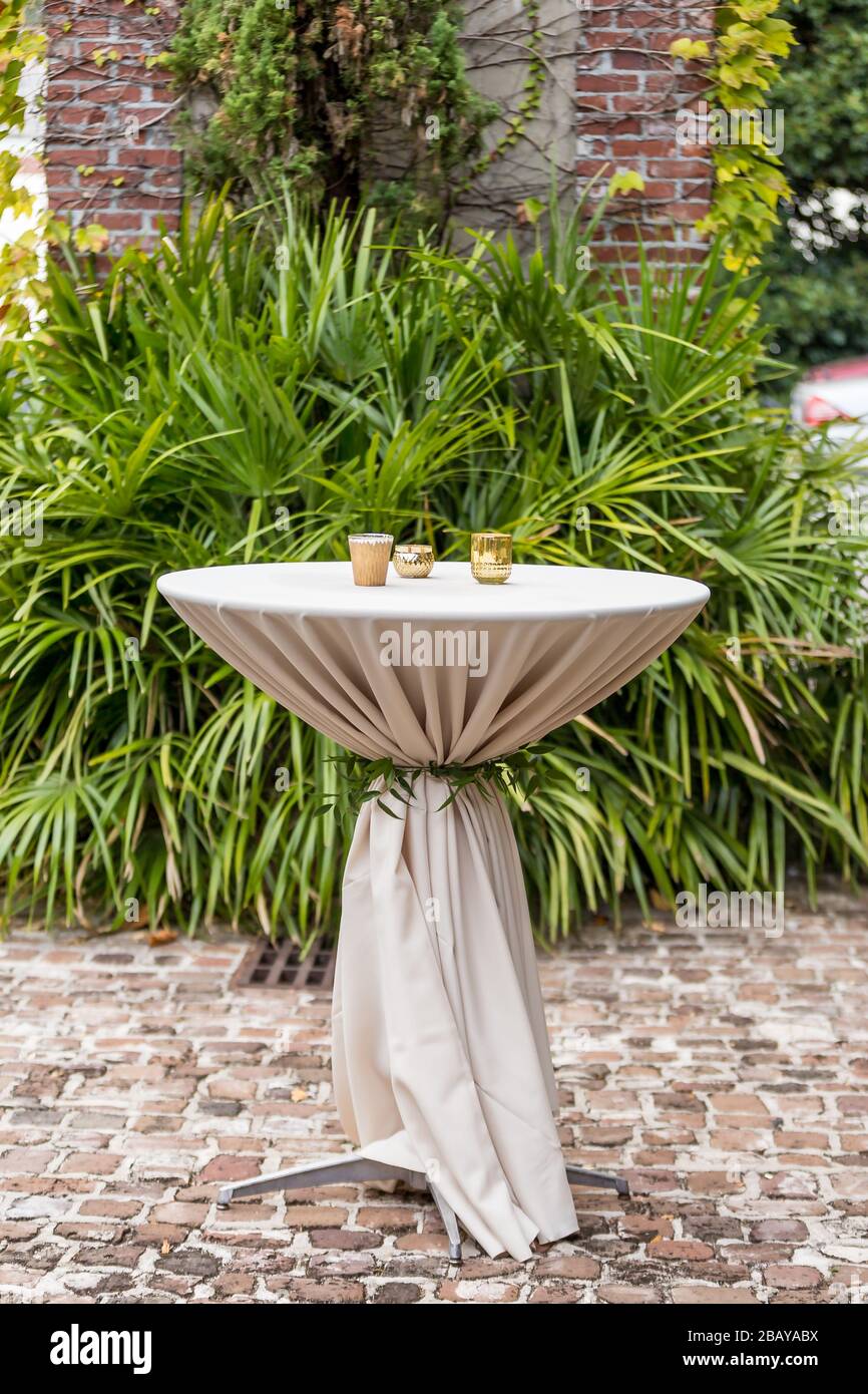 Vertical shot of an elegant outdoor tall table with green plants in the ...