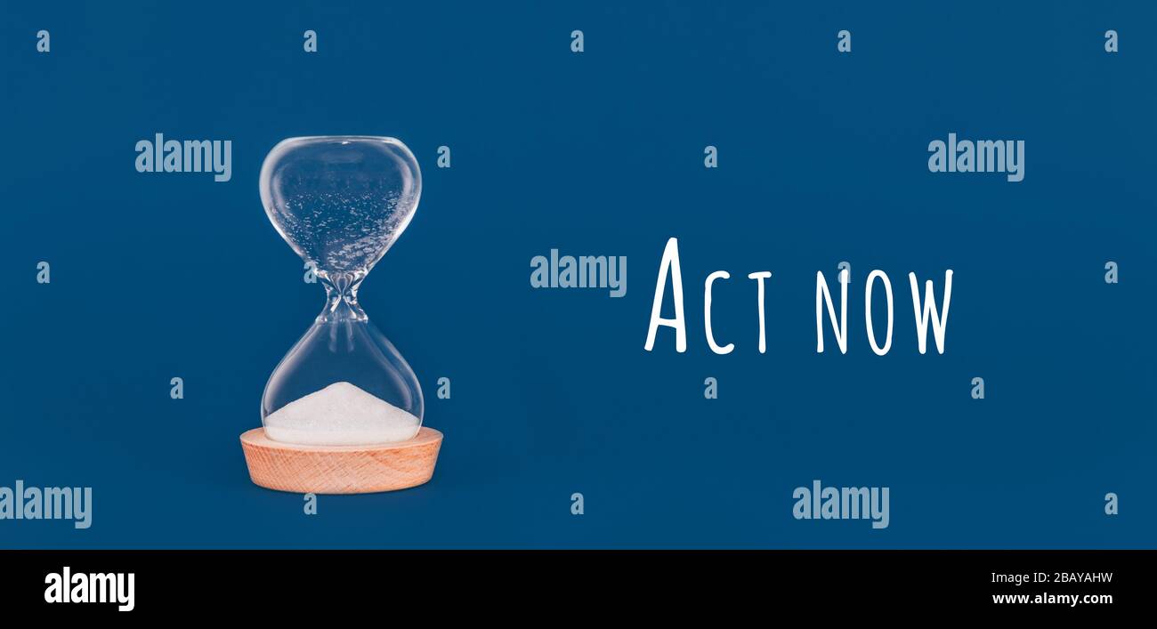 Hourglass with the finished sand with Act now wording. Concept of time ...