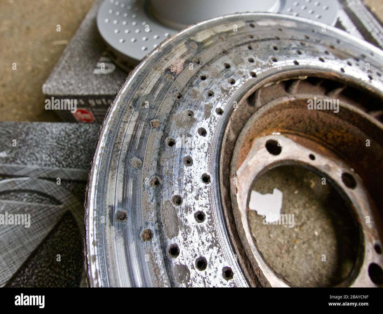 Worn out car brake disc sitting on garage floor Stock Photo - Alamy