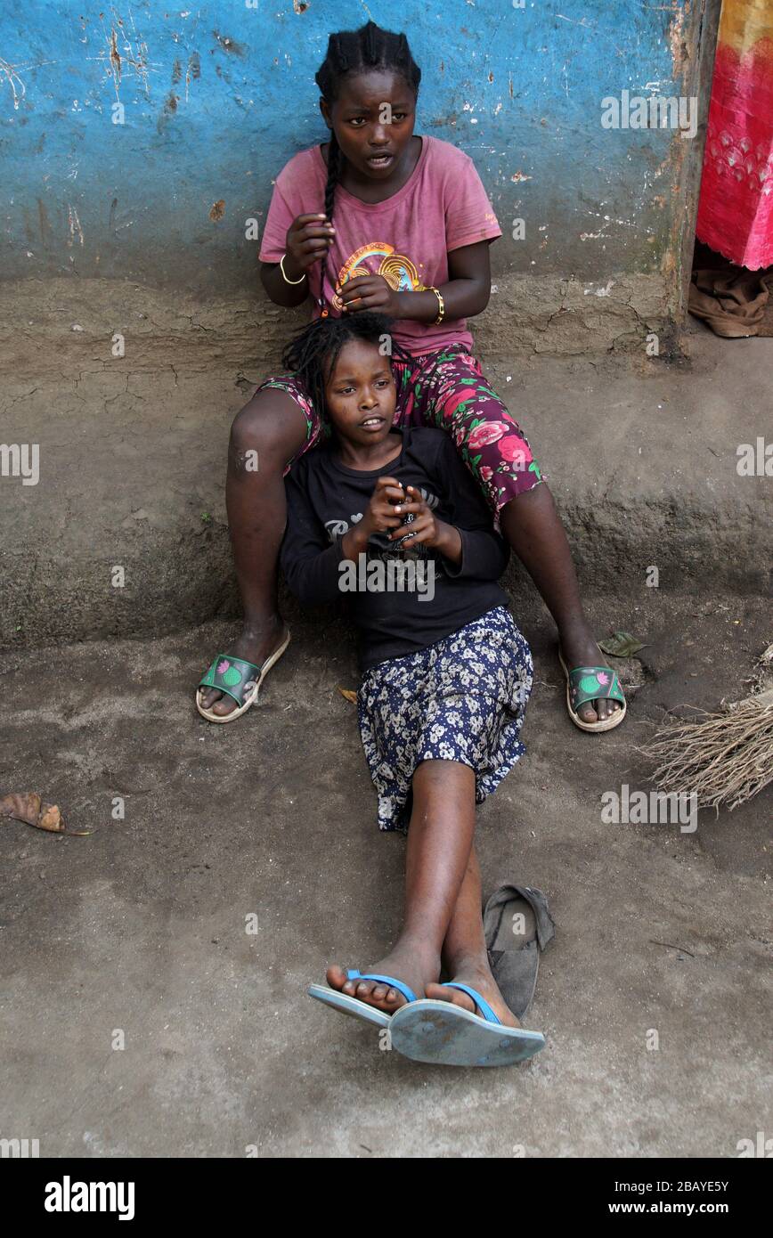 Young Girl braiding another Girl’s Hair in a Traditional Ari Style ...
