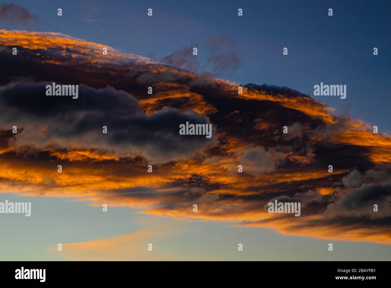 Strato-cumulus cloud with a setting sun shining through it creating a ...