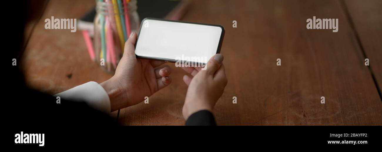 Cropped shot of female freelancer holding horizontal blank screen ...