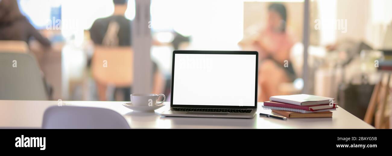 Cropped shot of office desk with blank screen laptop and notebooks on ...