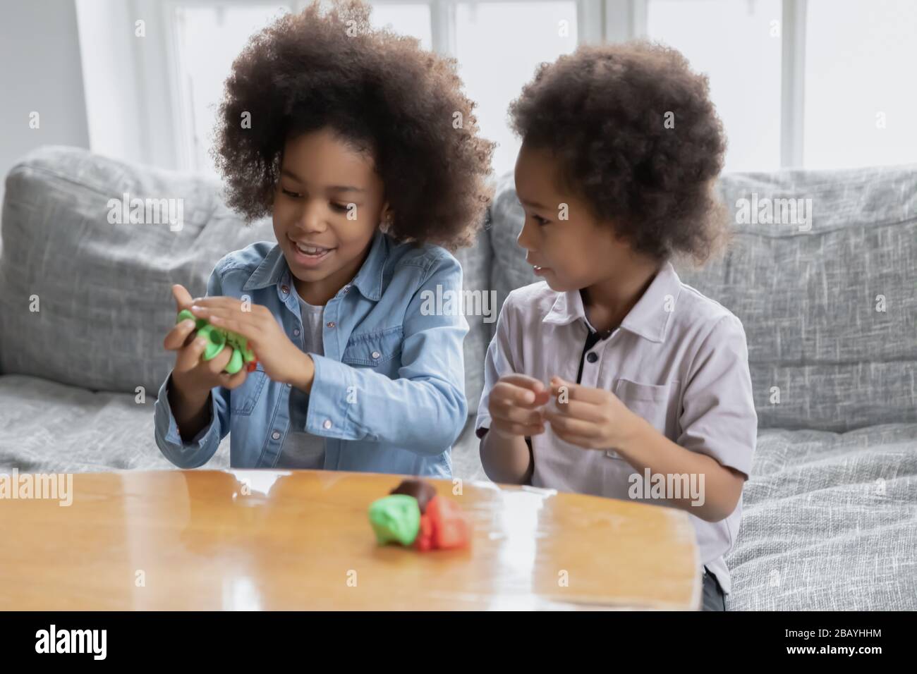 African siblings using playdough have fun making diverse shapes Stock ...