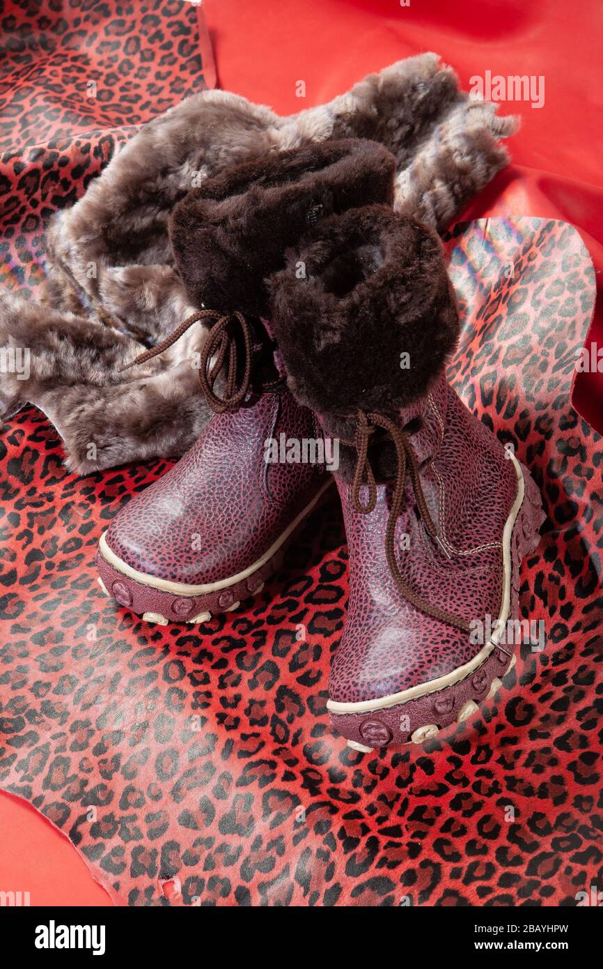 Shoes, shoemaking tools and pieces of leather on a studio background ...