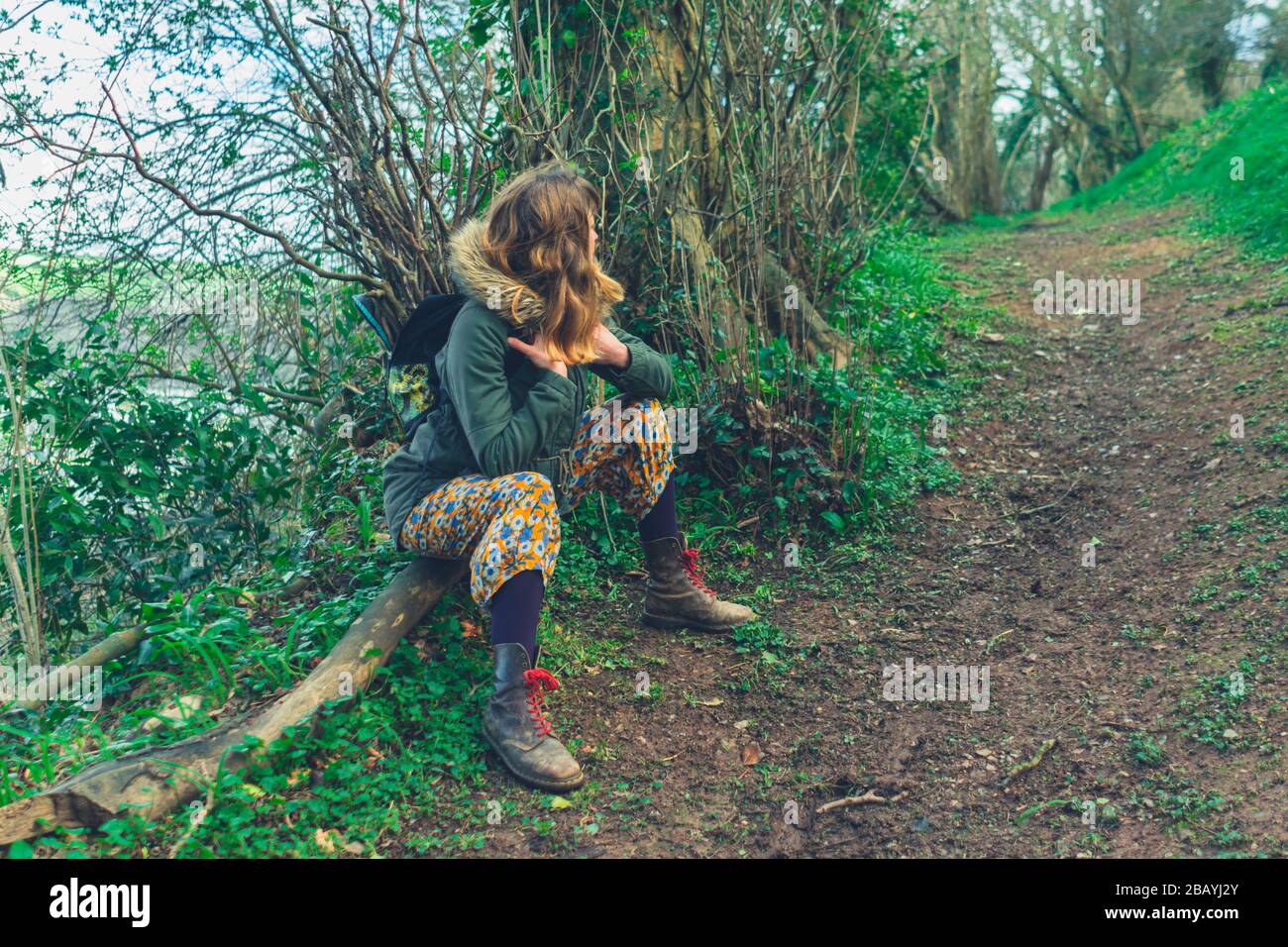 A young woman is relaxing after collecting sticks in the woods Stock ...