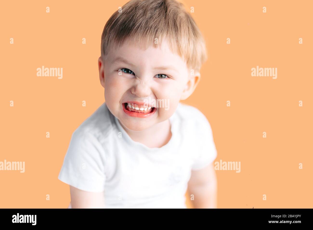 Beautiful young boy toddler laughs as he shows his white teeth Stock ...
