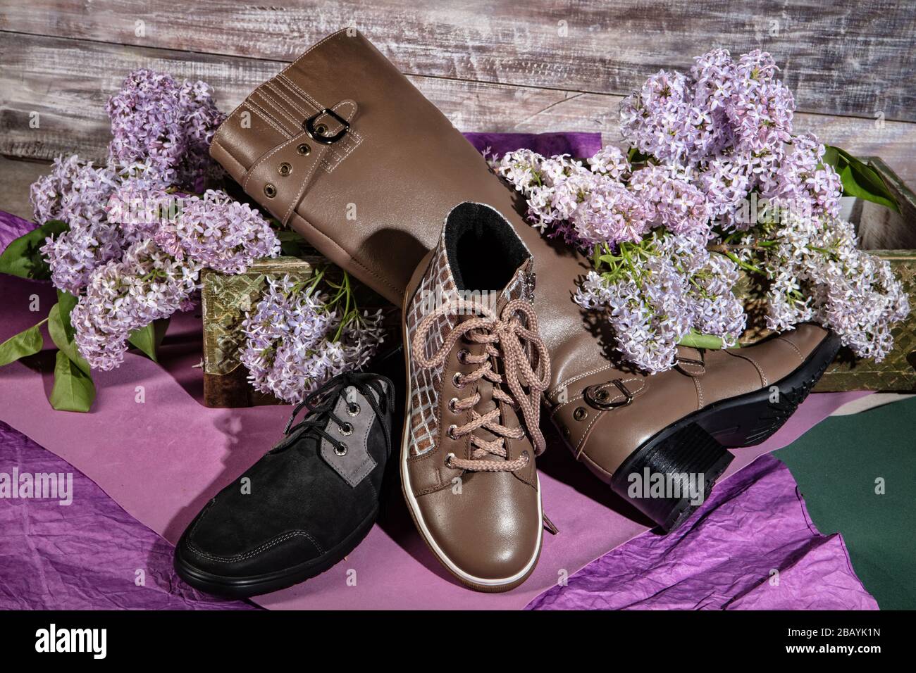 Different shoes on a wooden studio background Stock Photo - Alamy