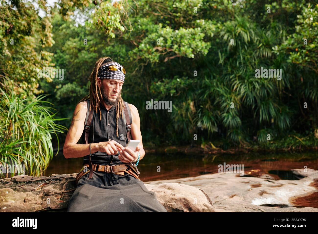 Frowning tousit checking map on his smartphone when he got lost in the ...