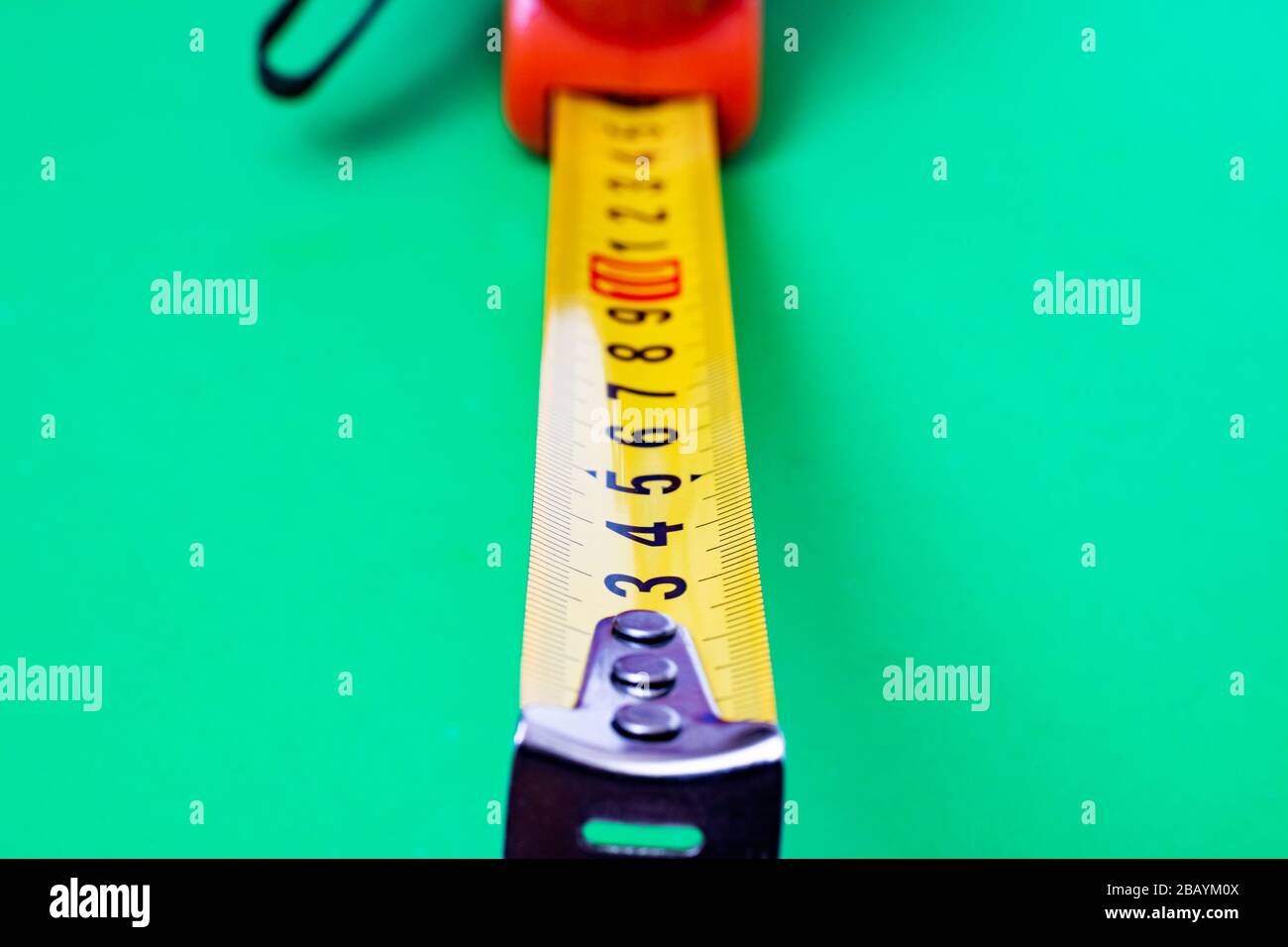 Measuring tape on a green background closeup Stock Photo - Alamy