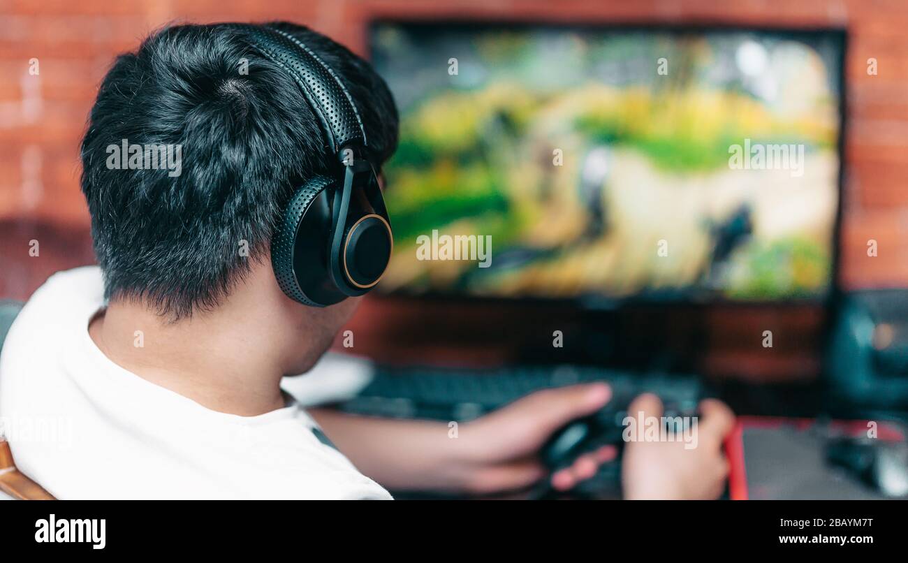 Man playing a computer games in headphones and console Stock Photo - Alamy