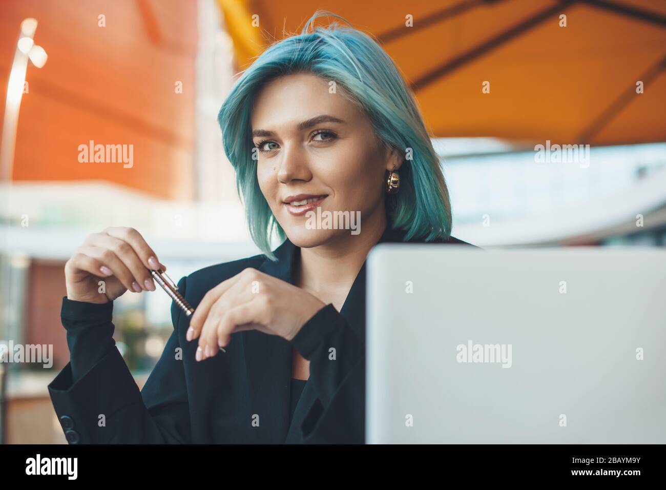 Caucasian student with blue hair working a cafeteria with a computer ...