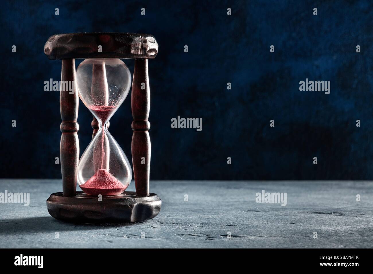 Time is running out concept. An hourglass with sand falling through, on ...