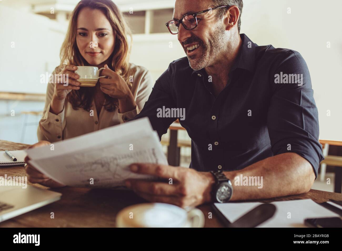 Two business colleagues working at coffee shop table. businessman ...