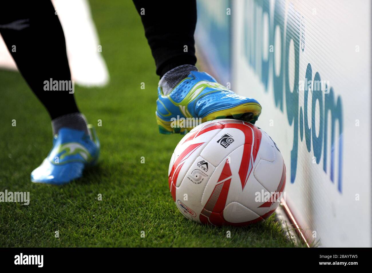 detail of a player retrieving a ball from beside an advertising board ...