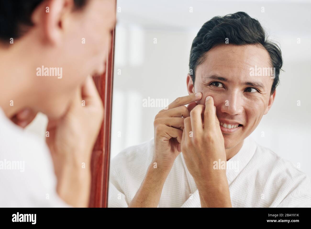 Portrait young man squeezing face hi-res stock photography and images ...