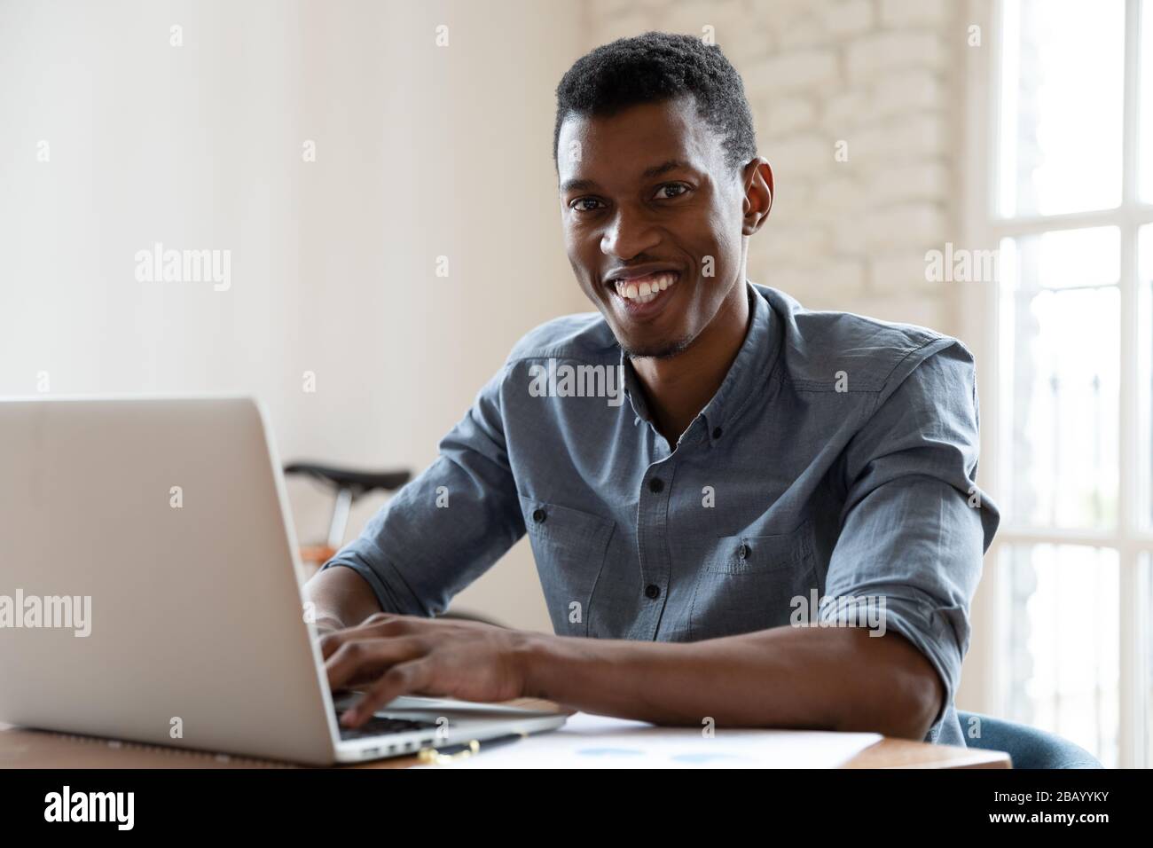 Smiling African businessman working sitting at workplace smile for ...