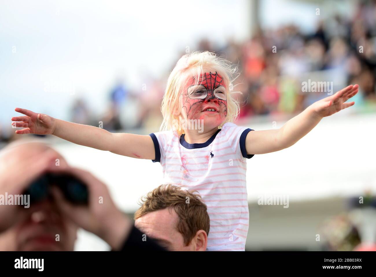 A child with facepaint watches the action during the Family Fun Raceday ...