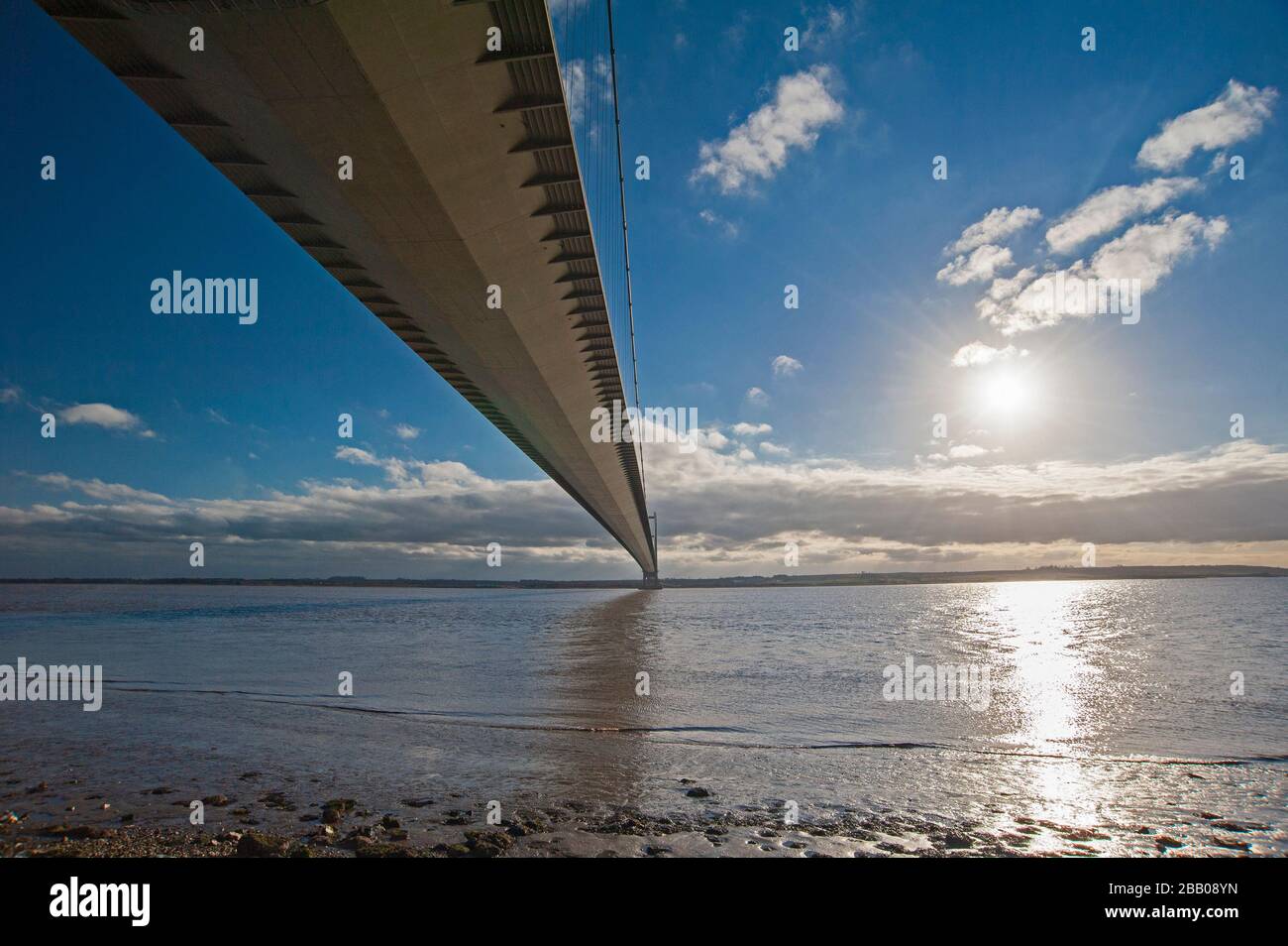 Large suspension bridge spanning a wide river estuary on a clear day ...