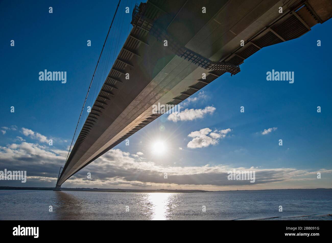 Large suspension bridge spanning a wide river estuary on a clear day ...