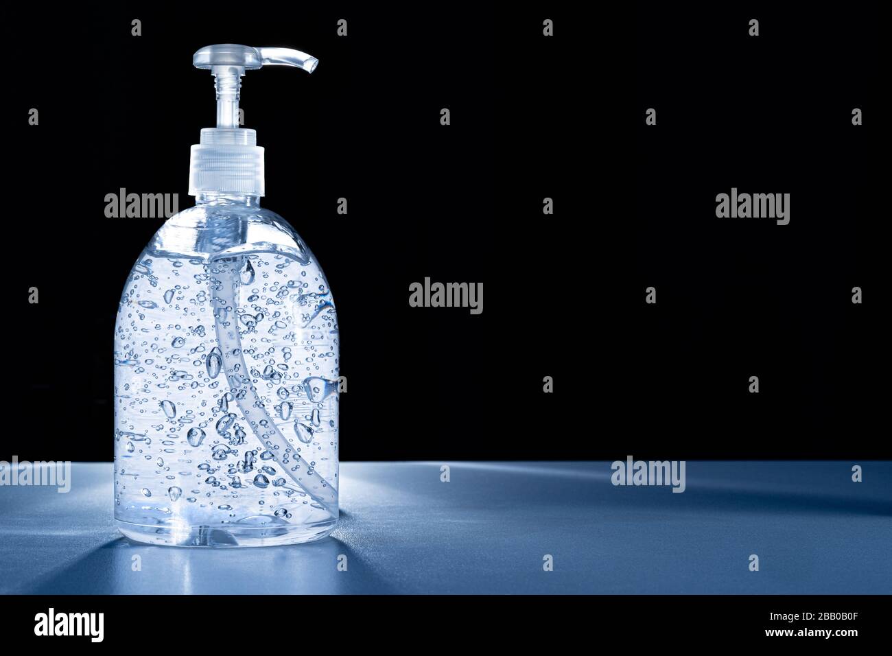 Anti-septic hand gel on white table with back lighting and black ...