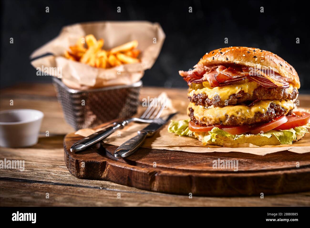Juicy burger on the board, black background. Dark background, fast food ...