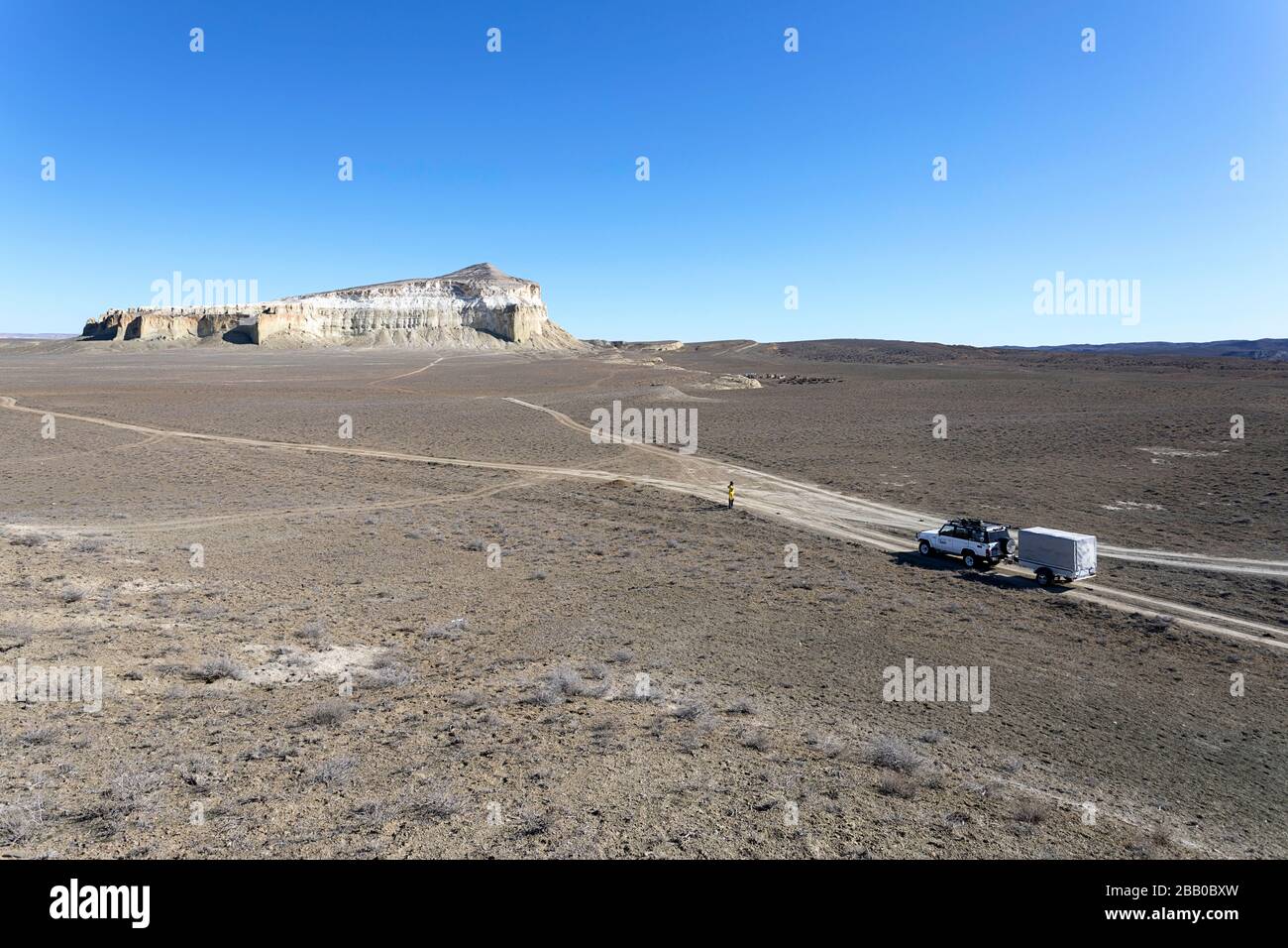 Mother and son and a 4x4 vehicle and trailer in the desert Lion rock ...