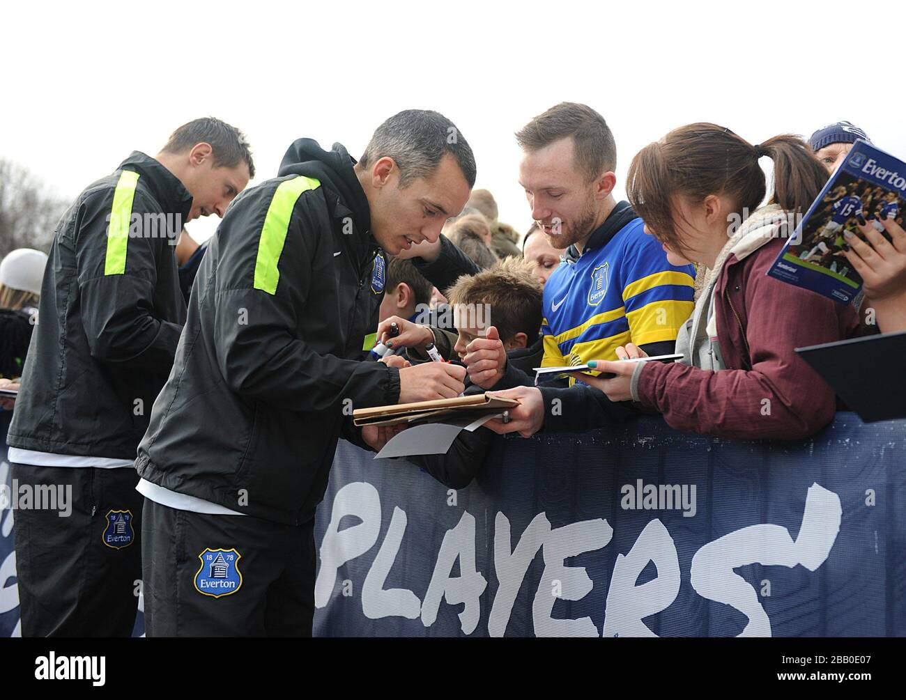 Everton's Leon Osman (right) and Phil Jagielka sign autographs on the ...