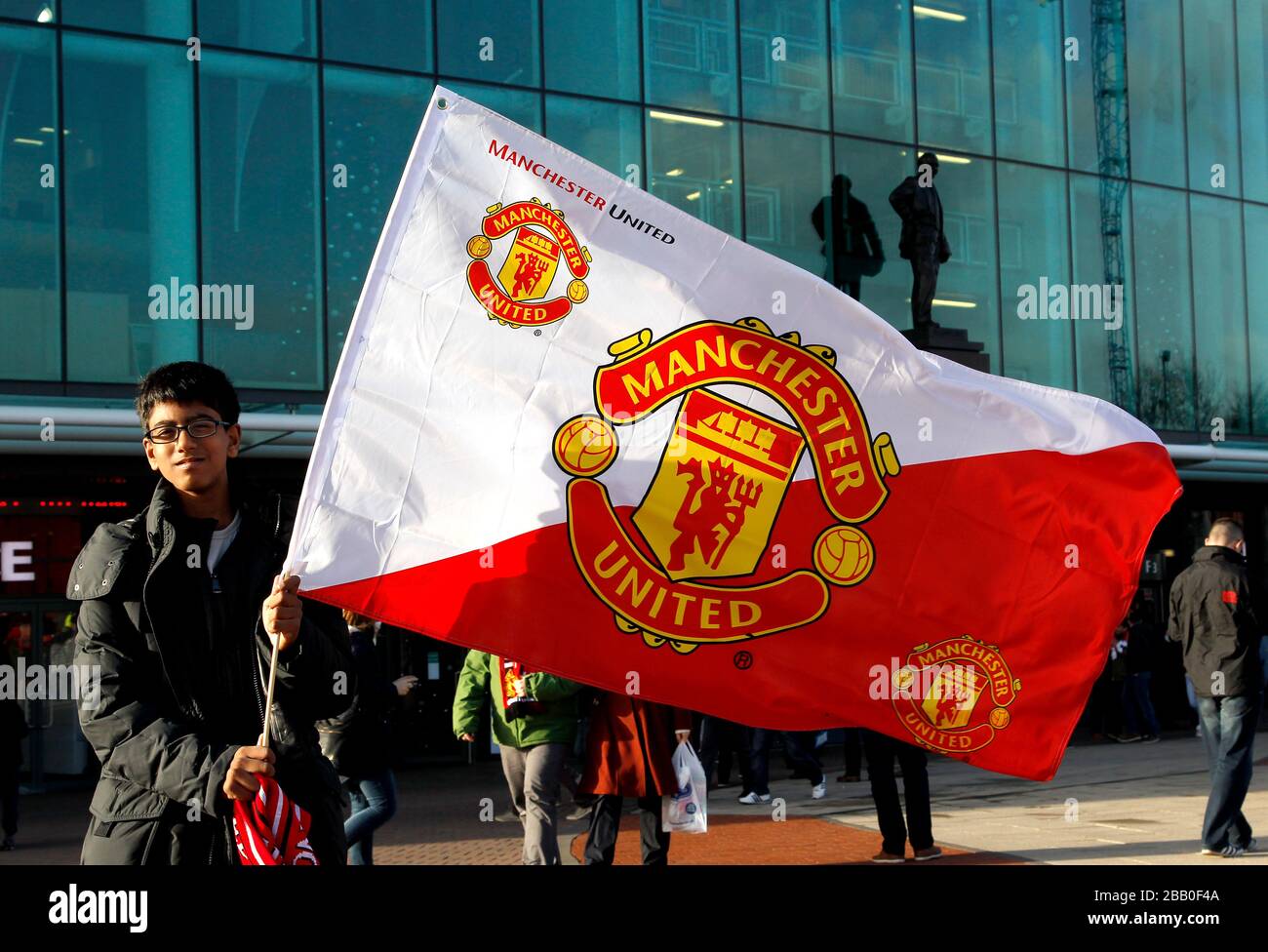 A young Manchester United fan waves a flag outside Old Trafford Stock ...