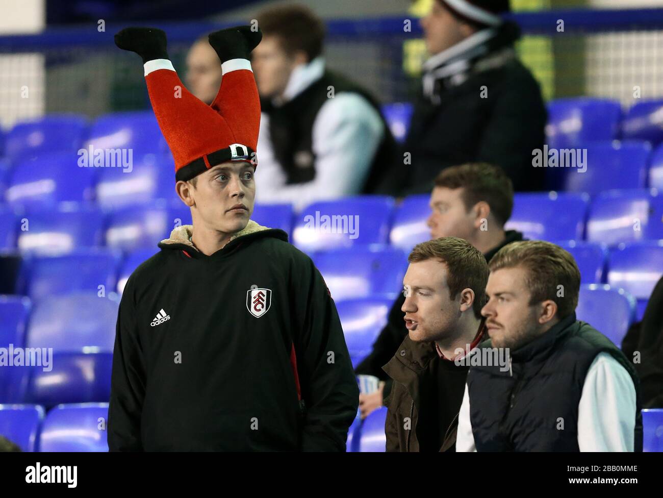 A Fulham fan wearing a festive hat in the stands Stock Photo - Alamy