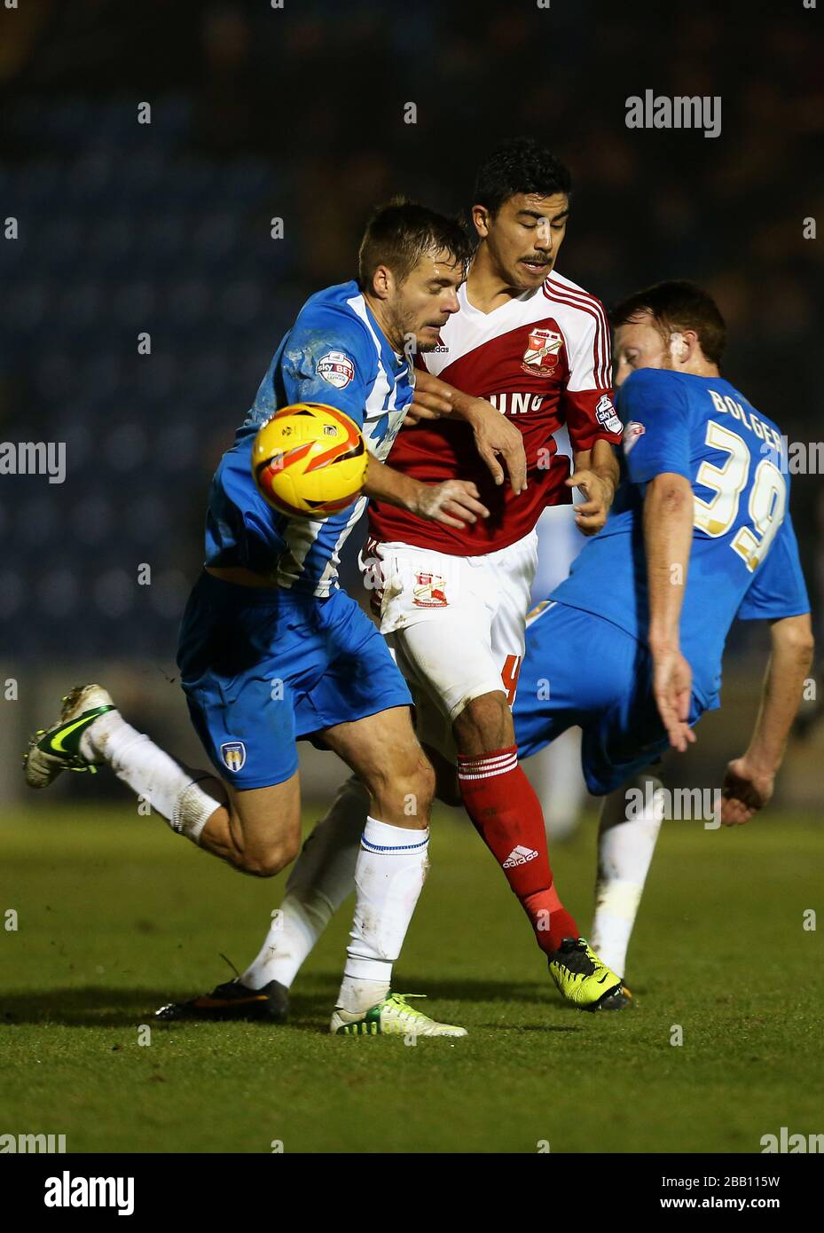 Swindon Town's Massimo Luongo is squeezed by Colchester United's Ryan ...