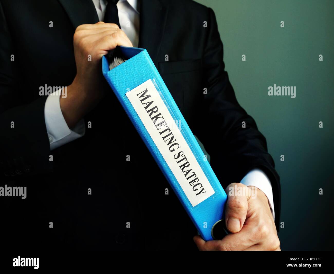 Marketer holds a folder with marketing strategy Stock Photo - Alamy