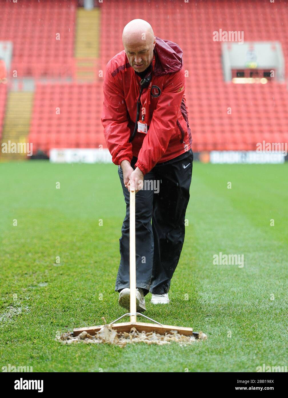 Groundstaff attempt to sweep the standing water off the pitch before ...
