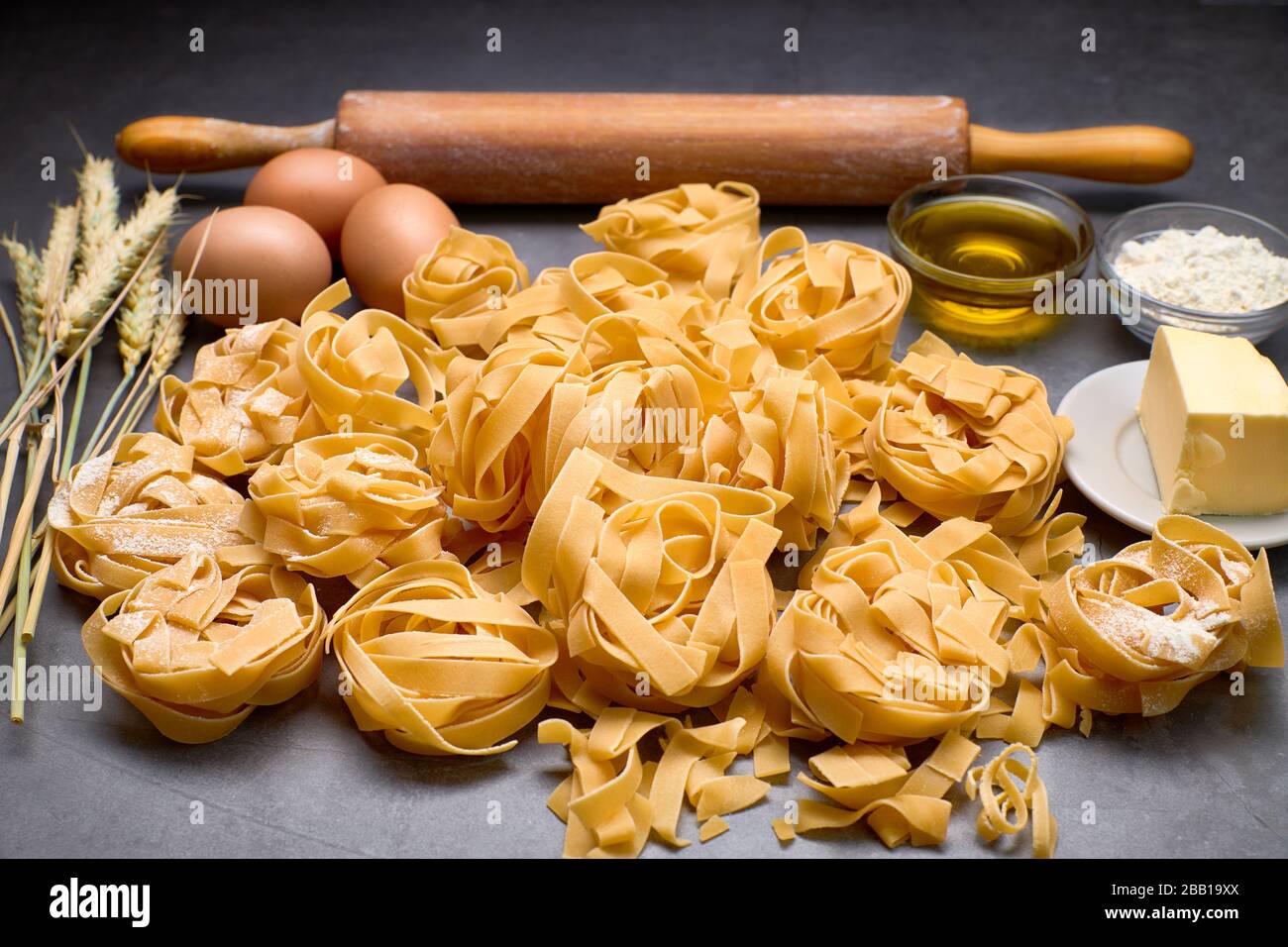 Italian pasta with some eggs, oil, flour, wood kneader and wheat ...