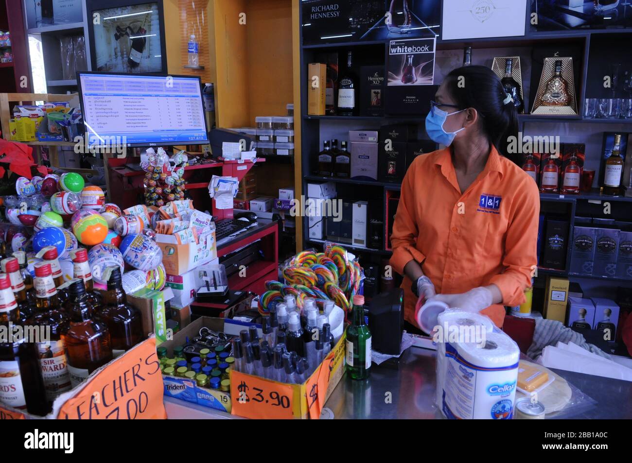 Wears wearing face mask masks cashier employee worker working hi-res ...
