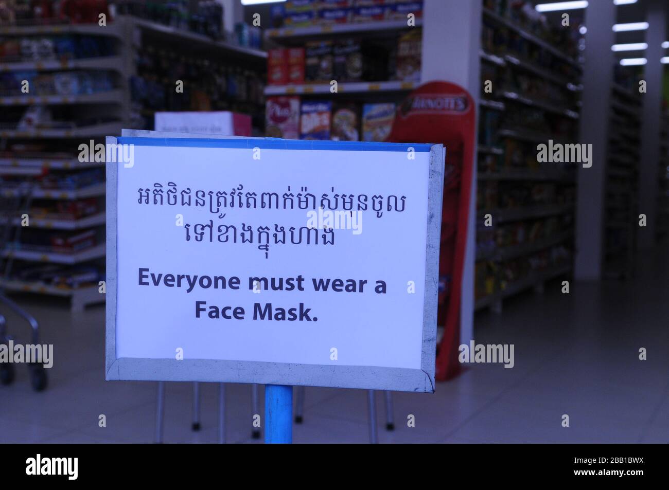 A supermarket displays a bilingual "Everyone must wear a Face Mask ...