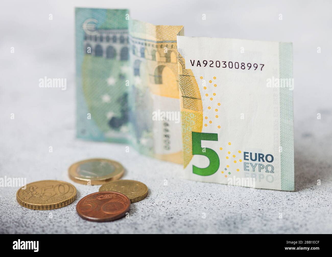 Five euro banknote with coins on light background. World economy crisis ...