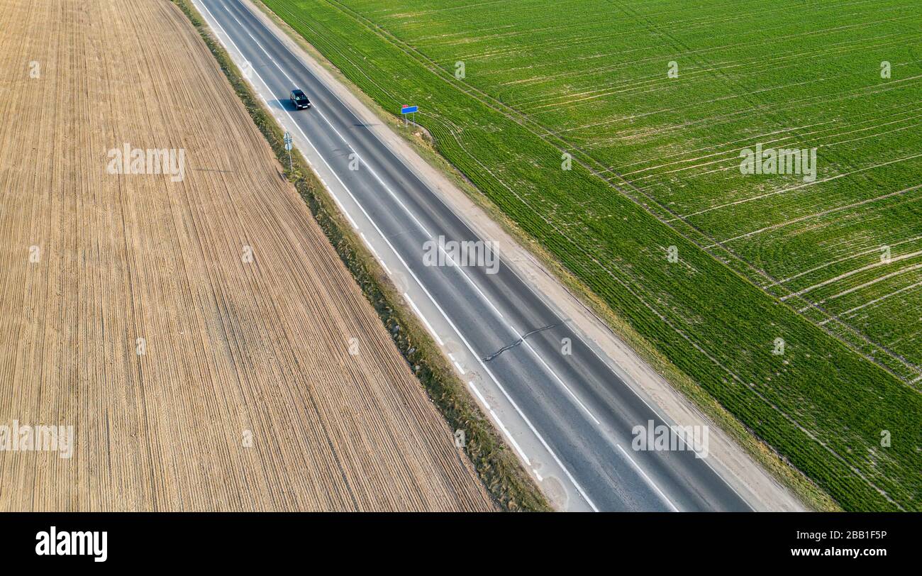 Aerial view of traffic on two lane road through countryside and ...