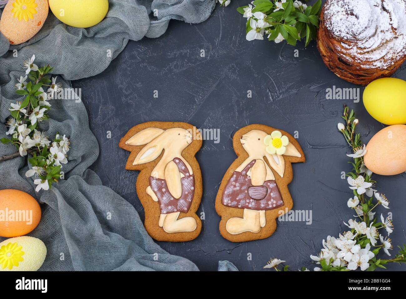 Easter gingerbread in the form of cute rabbits are located on a dark ...