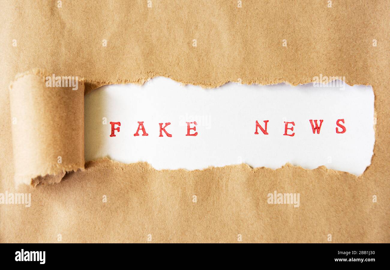 Words Fake News written under torn paper. Flat lay, top view Stock ...