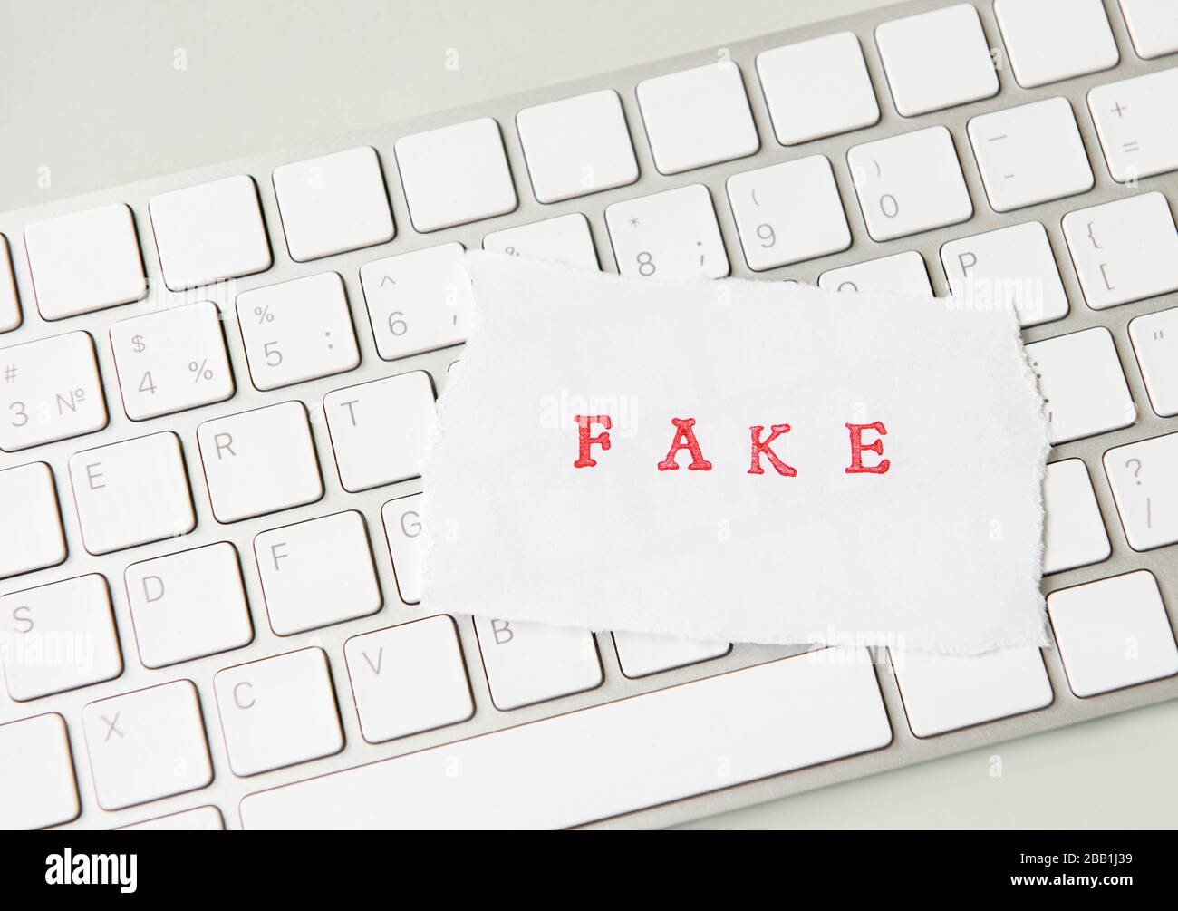 Word Fake written on torn paper on a computer keyboard Stock Photo - Alamy