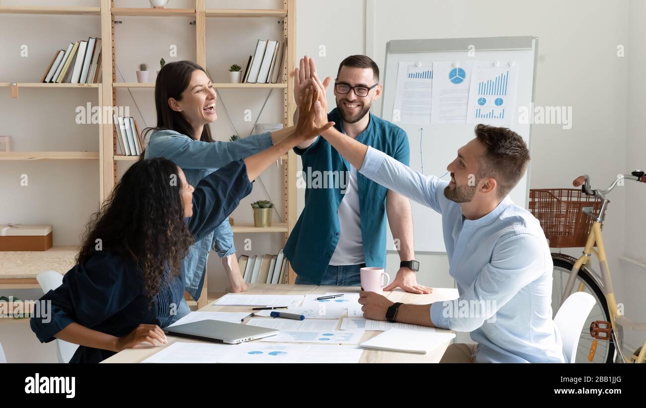 Happy diverse colleagues engaged in teambuilding activity at meeting ...