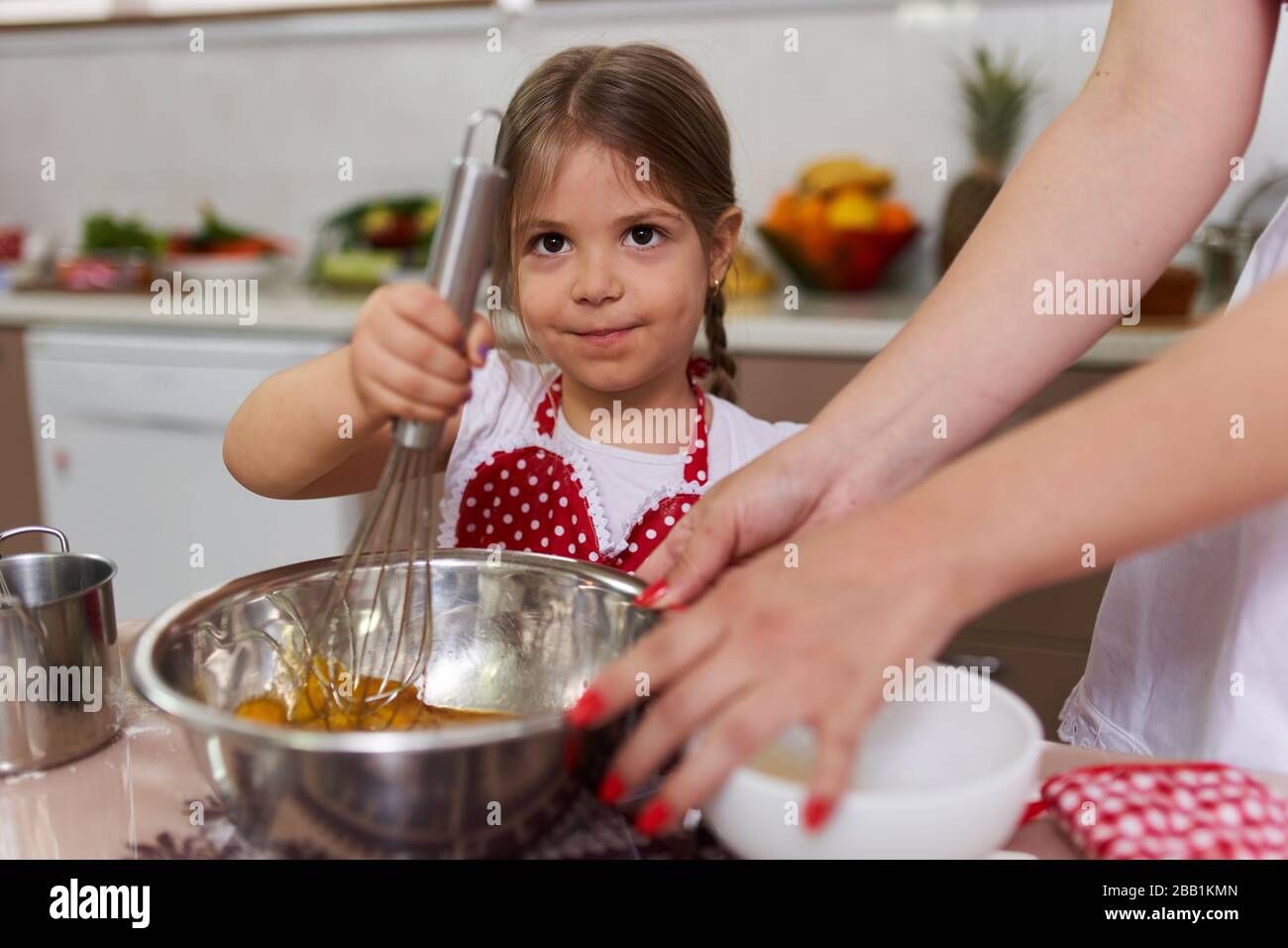 Little girl helping her mother cooking in the kitchen Stock Photo - Alamy