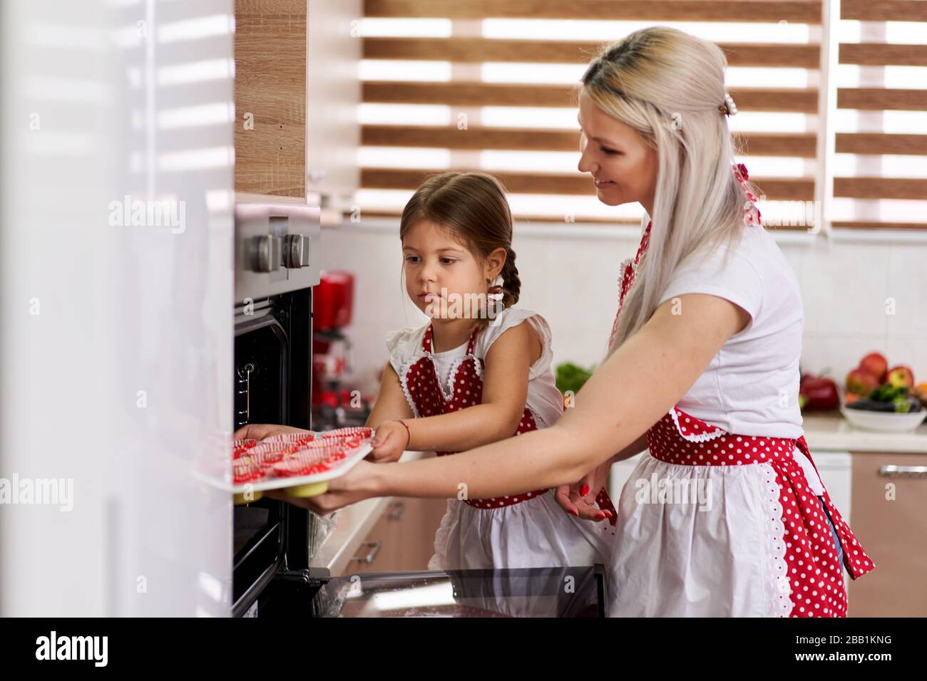 Little girl helping her mother cooking in the kitchen Stock Photo - Alamy